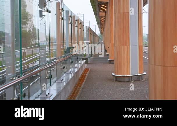 Empty railway station platform features sleek glass barriers and ...