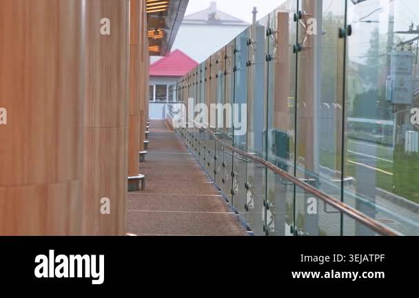 Long narrow railway station corridor features warm wooden columns on ...