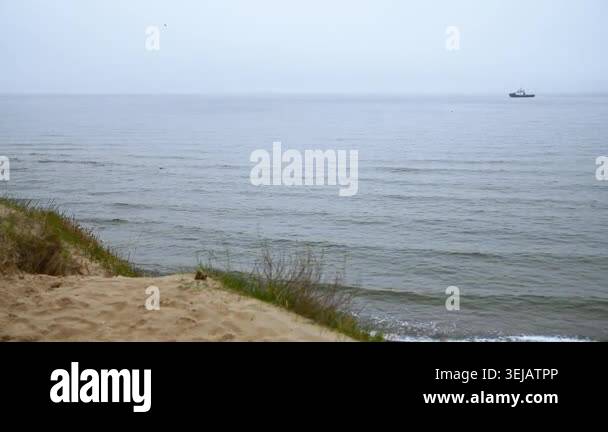 Quiet sea scene showing gentle waves and distant fishing boat under ...