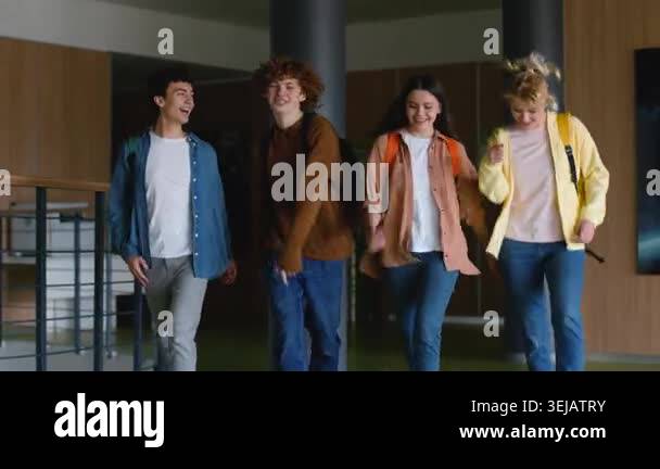 Happy teenagers guys girls students walk in school jumping celebrate ...
