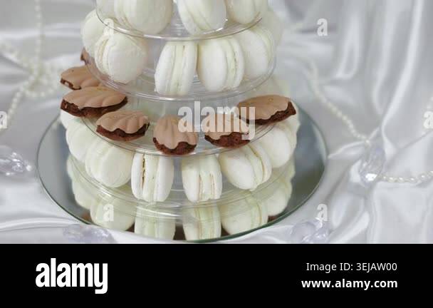 Close-up of white macaron tower and shell shaped chocolate cookies at a ...