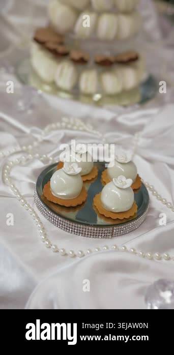 Elegant pyramid of white macarons and chocolate shell cakes at a candy ...