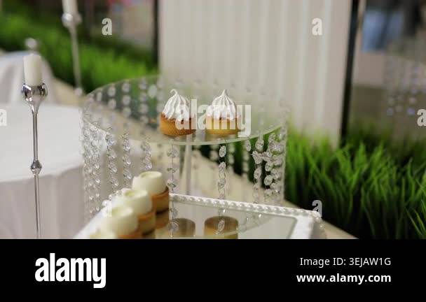 Waiter in gloves placing elegant meringue tartlets on a crystal glass ...
