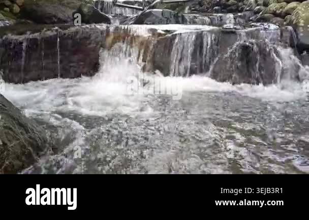 short waterfall with clear, fresh water in the mountainous area of ...
