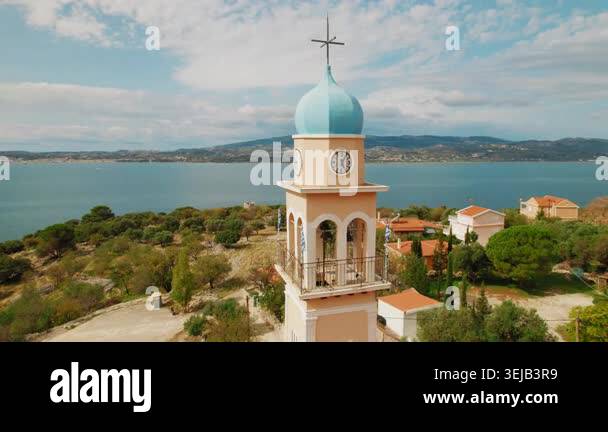 Clock tower with blue dome overlooking Ionian Sea and coastal houses ...