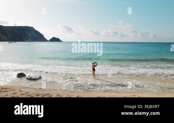 Woman enjoying calm morning on beach with turquoise sea in Kefalonia ...