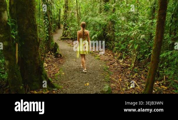 Young woman walking along rainforest path in Costa Rica during tropical ...