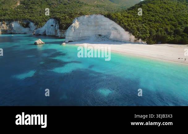 White pebble beach and turquoise sea near cliffs in Kefalonia Greece ...