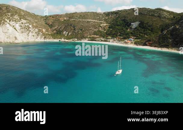 Sailboat anchored in turquoise bay near rocky cliffs at Petani beach on ...