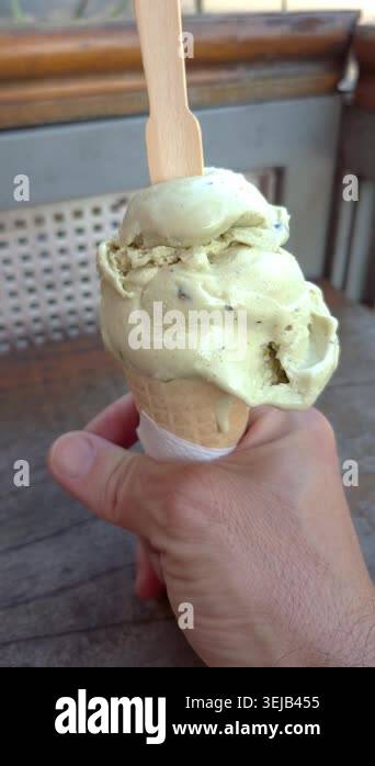 Closeup of pistachio ice cream with pistachio pieces in a wafer cone ...