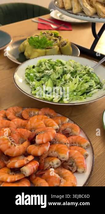 richly set festive table on a wooden surface with shrimp, cabbage salad ...