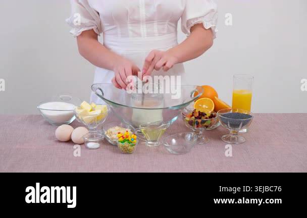 female pastry chef pours dry yeast into glass jar and carefully mixes ...