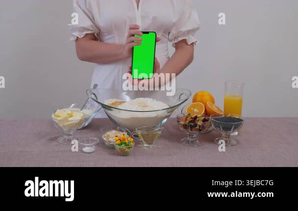 green screen while preparing sweet pastry near flour, oranges, raisins ...