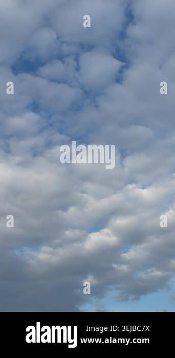A calm and clean view of soft white clouds drifting across a clear blue ...