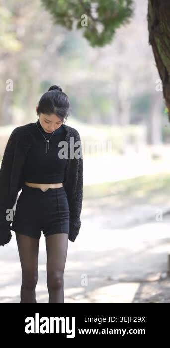 Woman wearing black outfit walking outdoors Stock Video Footage - Alamy