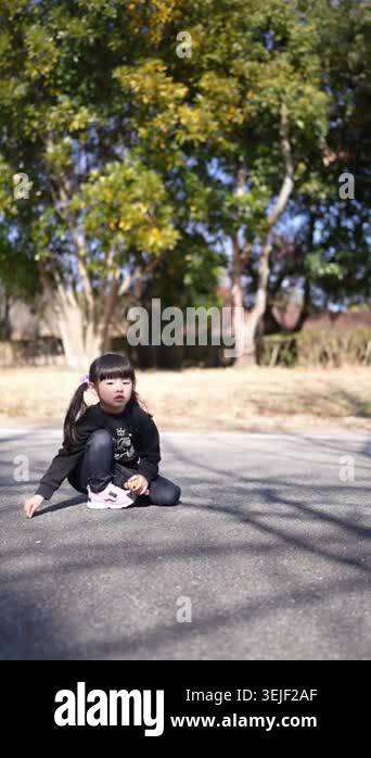 Young girl sitting outdoors near trees Stock Video Footage - Alamy