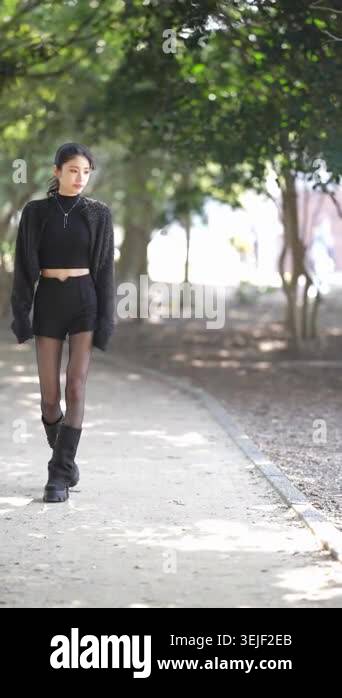Woman walking along path wearing black outfit Stock Video Footage - Alamy