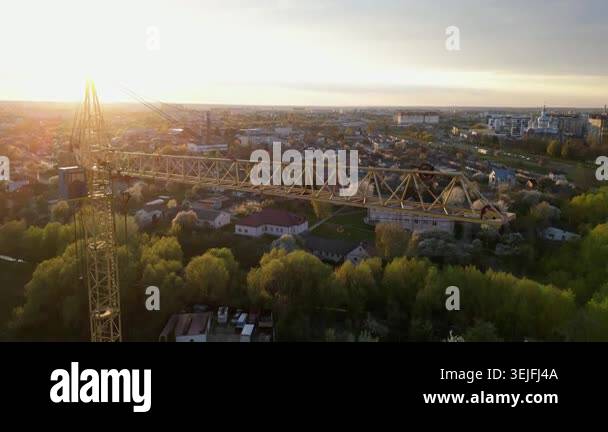 Aerial footage showing a yellow tower crane on a construction site with ...