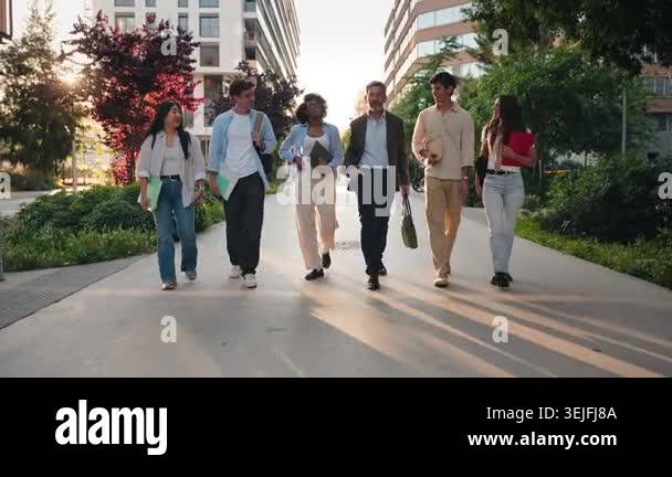 Group of students walking together with University professor on city ...