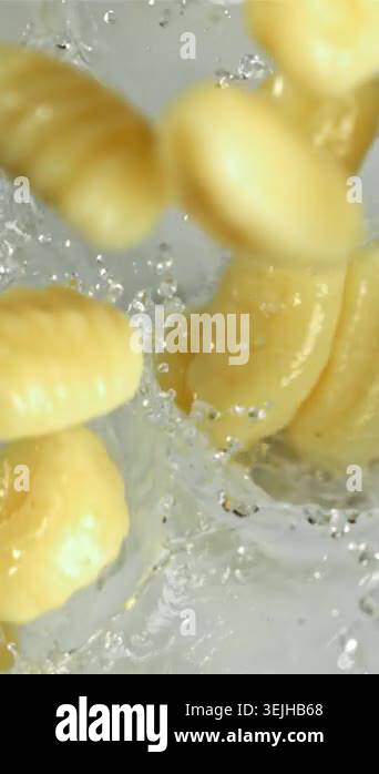 Italian gnocchi fall into the water with splashes. Filmed on a high ...