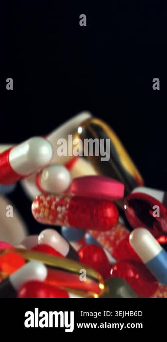Assorted capsules and softgels floating against black, cinematic Filmed ...