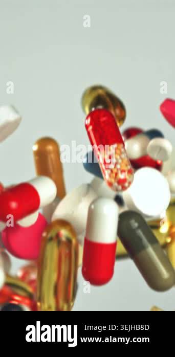 Assorted supplements and capsules drifting against soft grey, vibrant ...