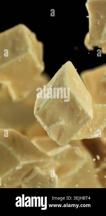 Pieces of white chocolate fly up and fall down. Filmed on a high-speed ...