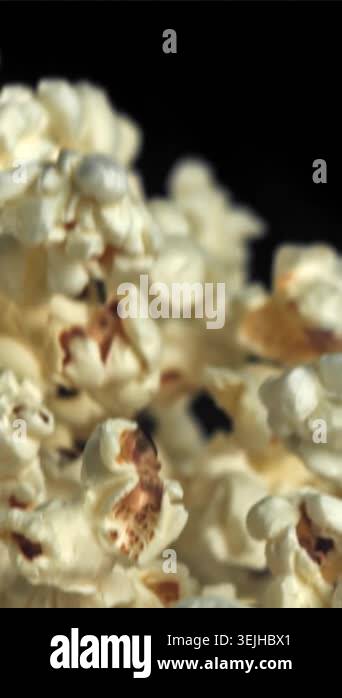 Popcorn flies up and falls down. On a black background. Filmed on a ...