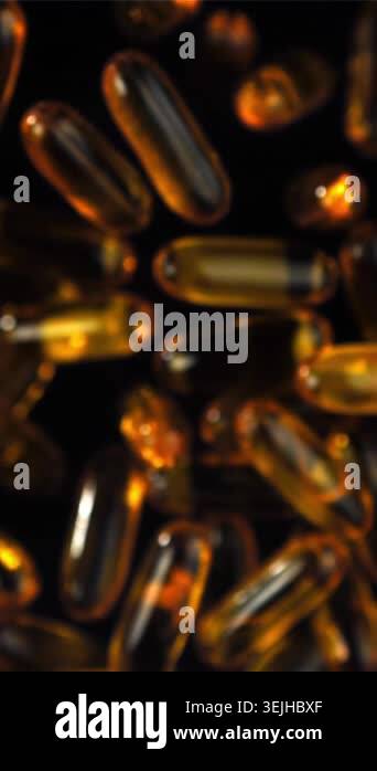 Floating amber softgel capsules on black. Premium closeup Filmed on a ...