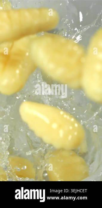 Italian gnocchi fall into the water with splashes. Filmed on a high ...