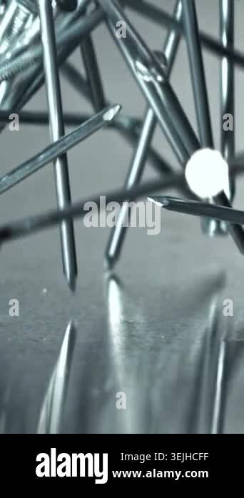 Cinematic nails cascading across steel surface, slowmotion kinetic ...