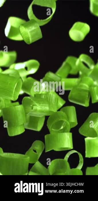 Sliced green onions fly up and fall down. Filmed on a high-speed camera ...