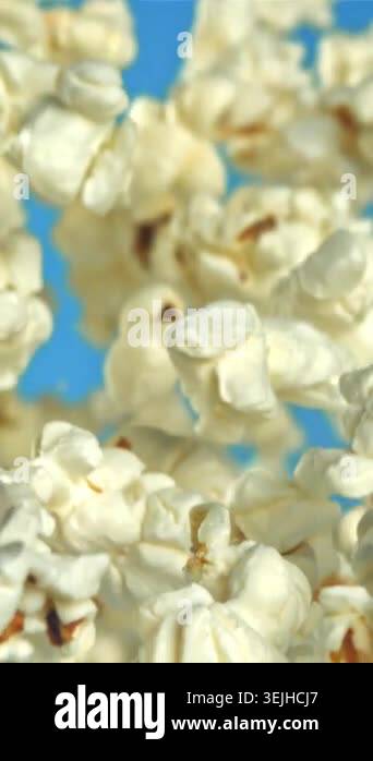 Popcorn flies up and falls down. On a blue background. Filmed on a high ...