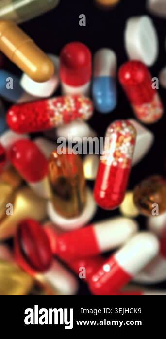 Floating gold and red capsules on black background, closeup luxurious ...