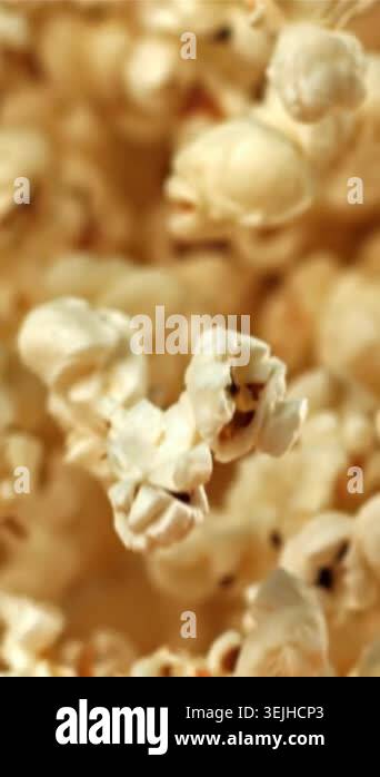 A bowl of popcorn falls on a yellow background. Filmed on a high-speed ...