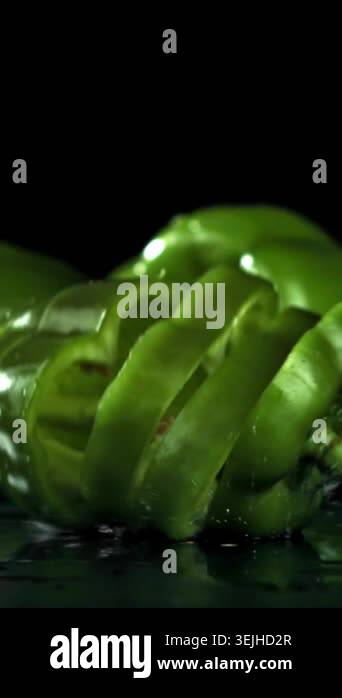 Studio closeup sliced green pepper rings falling and splashing Filmed ...