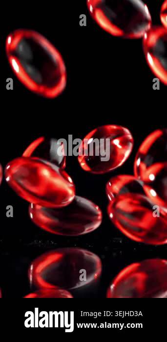 Red gel capsules on black surface, dramatic lowkey lighting Filmed on a ...