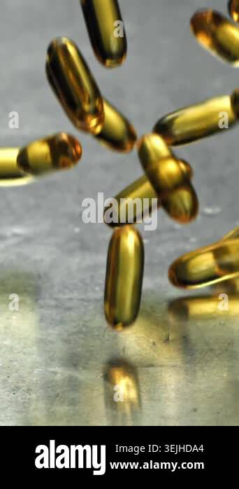 Golden softgel capsules cascading on metal premium supplement imagery ...