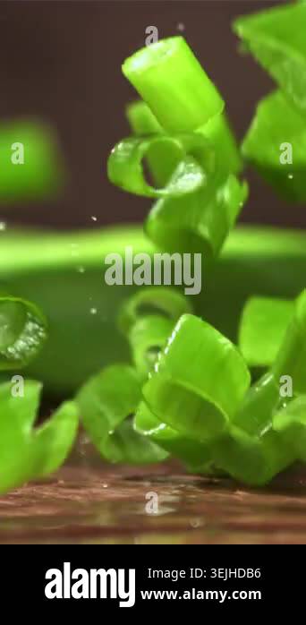The chopped green onions fall onto the cutting board. Filmed on a high ...