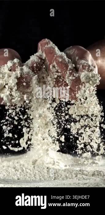 Chef sprinkles flour on the kitchen table. Filmed on a high-speed ...