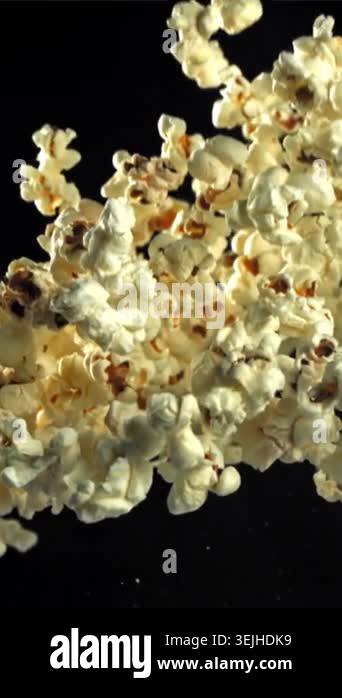 Popcorn flies up and falls down. On a black background. Filmed on a ...