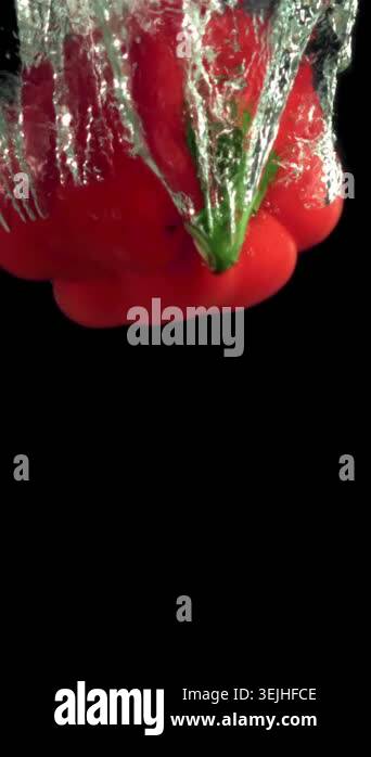 Super slow motion red bell pepper falls under the water with air ...