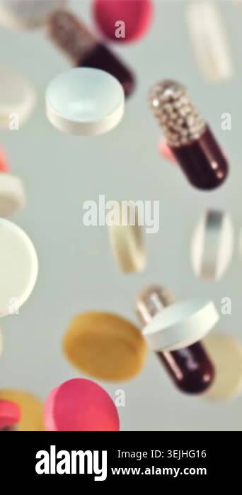 A bunch of different pills fly up and rotate in flight. On a white ...