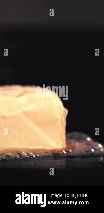 Super slow motion a piece of butter with a fork melts in a frying pan ...