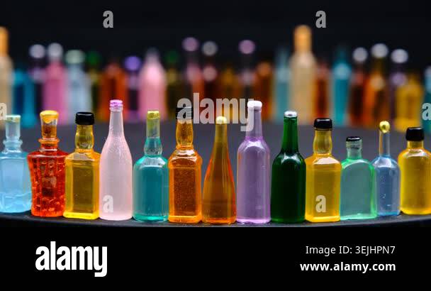 various miniature resin bottles of alcohol without labels in motion on ...