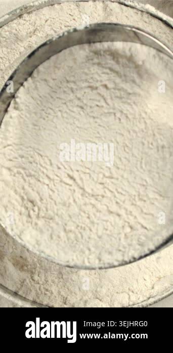 The super slow motion of the sieve falls into a pile of flour on the ...