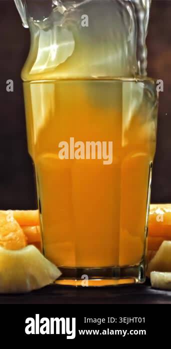 Piece of pineapple falls into pineapple juice. Filmed is slow motion ...
