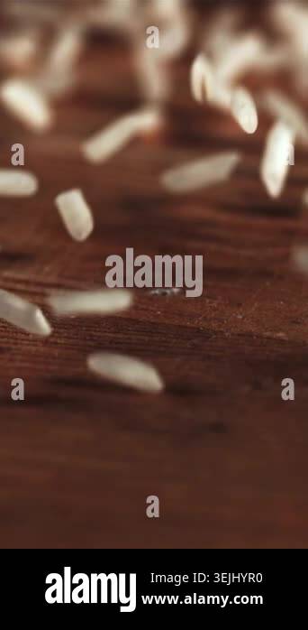 Raw rice is scattered on the table and rotated. On a wooden background ...