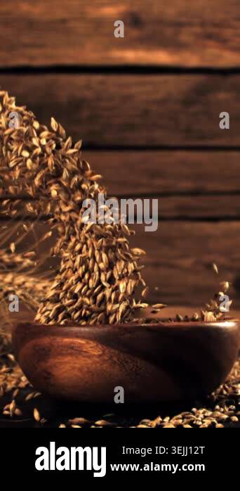 Super slow motion plate of wheat grains falls on the table. On a wooden ...