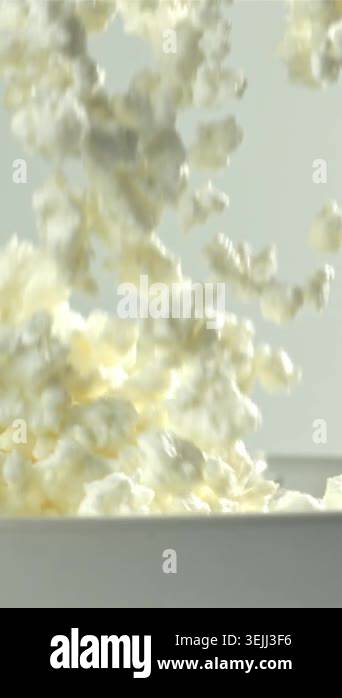 Fresh cottage cheese falls into the bowl. Filmed on a high-speed camera ...